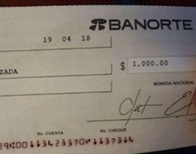 Muestra docente su cheque de mil pesos